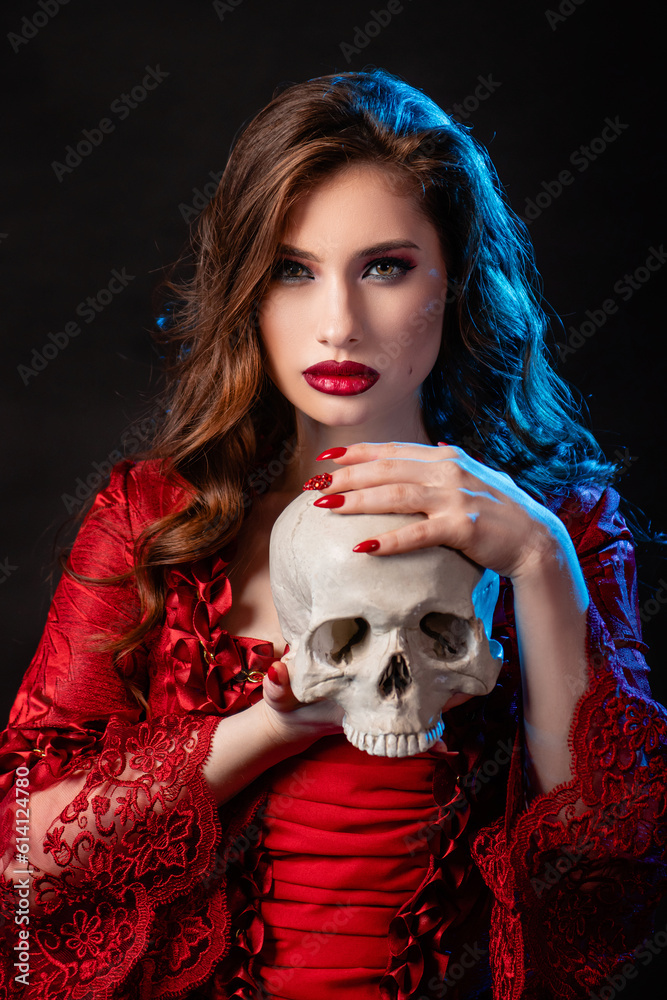 Portrait of a young, attractive vampire woman in a red dress in the ...
