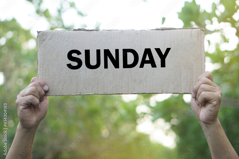 Hands hold word card for teaching with word SUNDAY. Concept, language ...