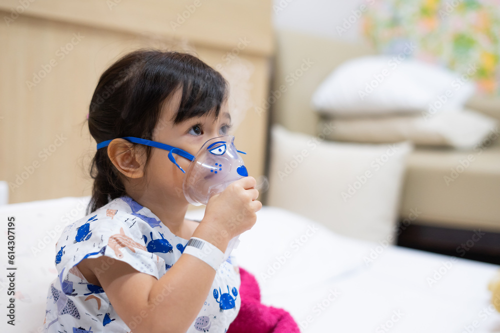 Little asian girl sick making inhalation with nebulizer to reduce ...