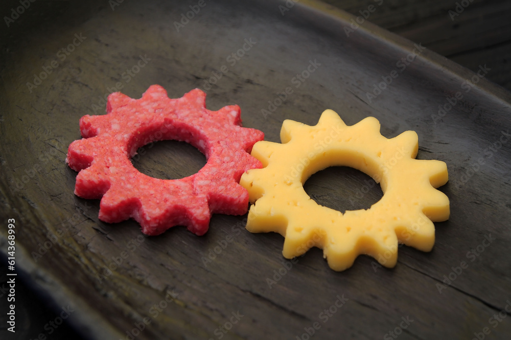 Concept sausage and cheese sliced in the shape of gears. Imitation of ...