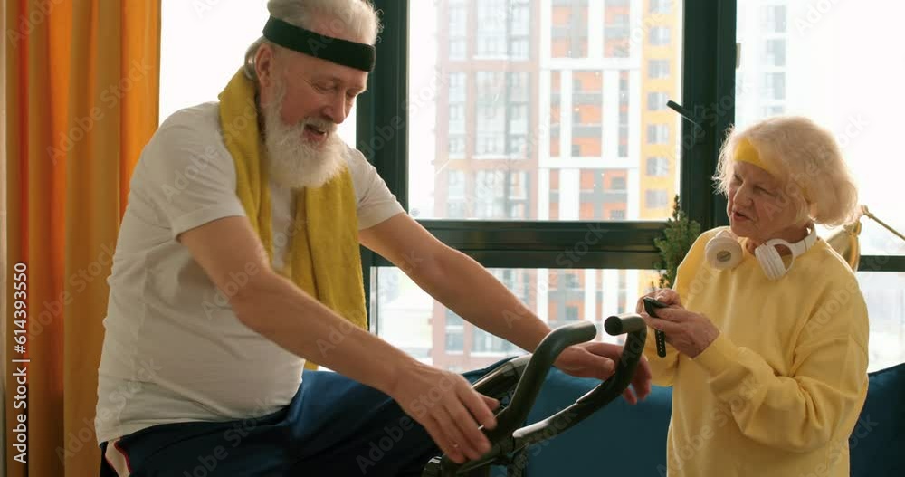 excited emotional active old people working out at home in bicycle ...