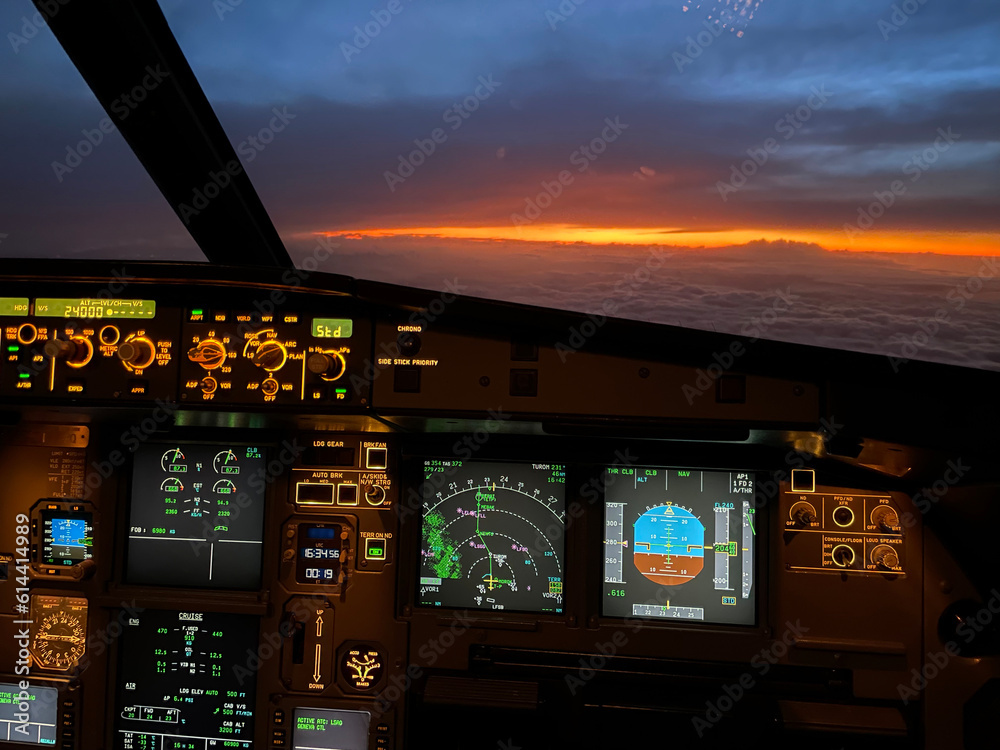 Flight deck cockpit of a modern airliner taken during cruise at sunset ...