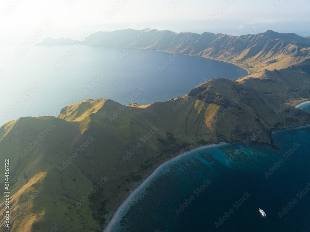 Healthy coral reefs fringe the volcanic island of Gili Banta near ...