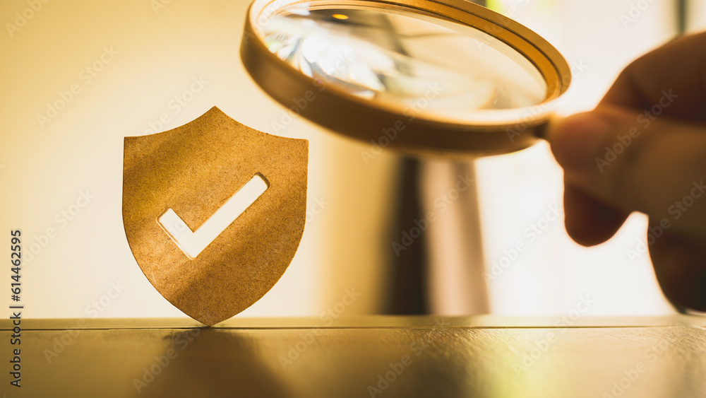 Foto de Hand holding magnifying glass and looking at shield protect icon, The concept of finding ...