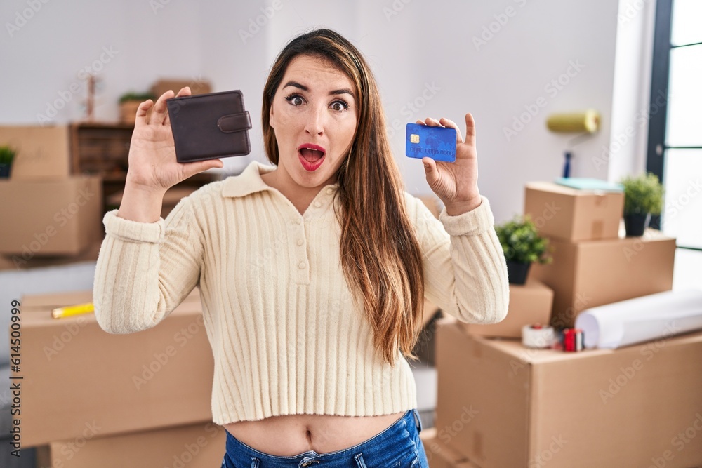 Foto de Young hispanic woman moving to a new home holding wallet and ...
