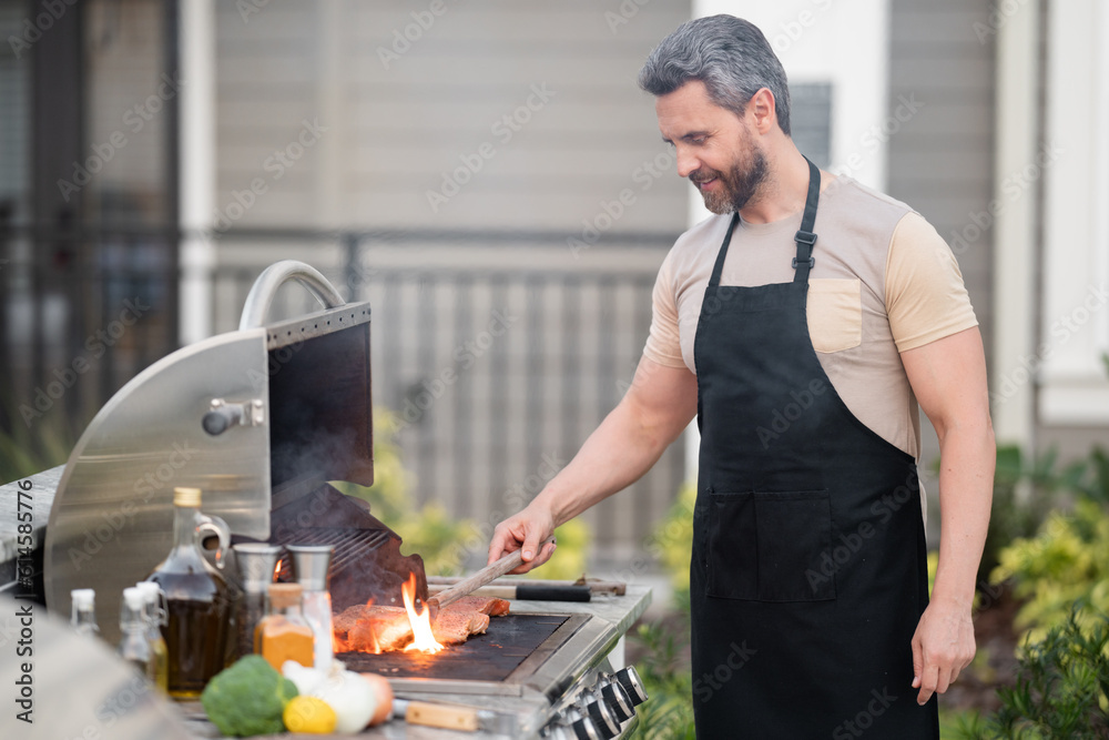 Hispanic man cooking on barbecue in the backyard. Chef preparing ...