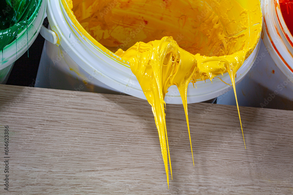 Yellow paint dripping from white barrel..plastisol ink is used for ...