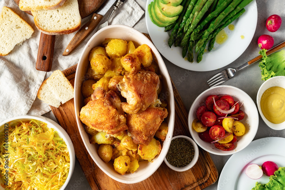 Home dinner table with set of various food from baked new potatoes with ...