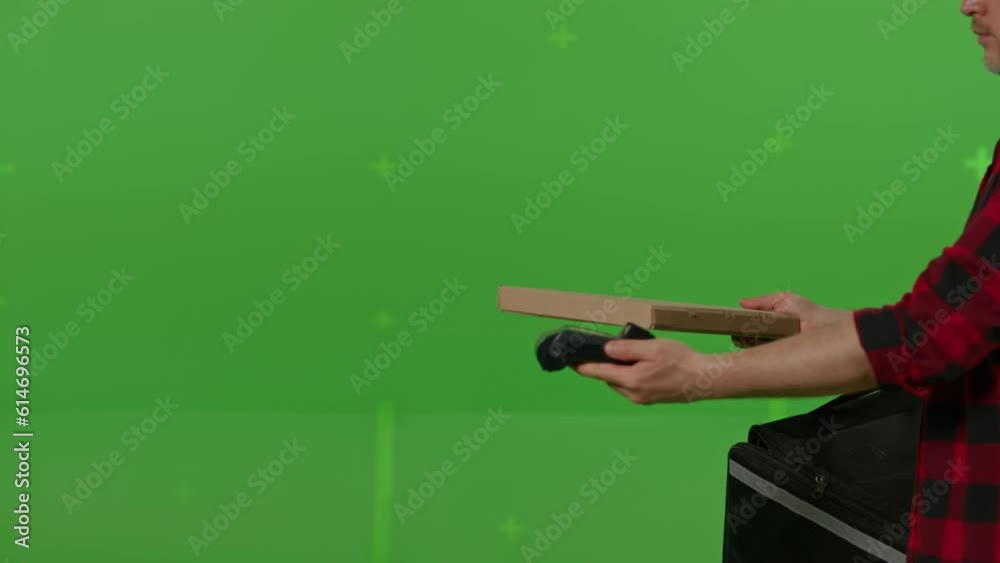 Caucasian male courier passing a box of pizza on green screen chroma ...