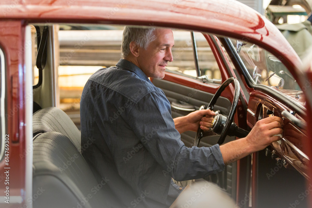 Mechanic inside classic car in auto repair shop Stock Photo | Adobe Stock