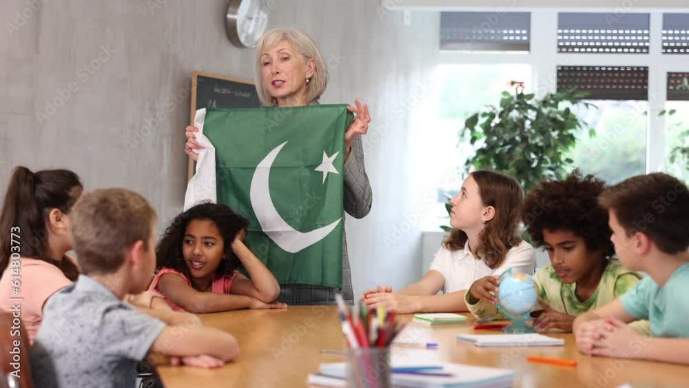 Female teacher showing pakistani flag to kids in geography class kids ...