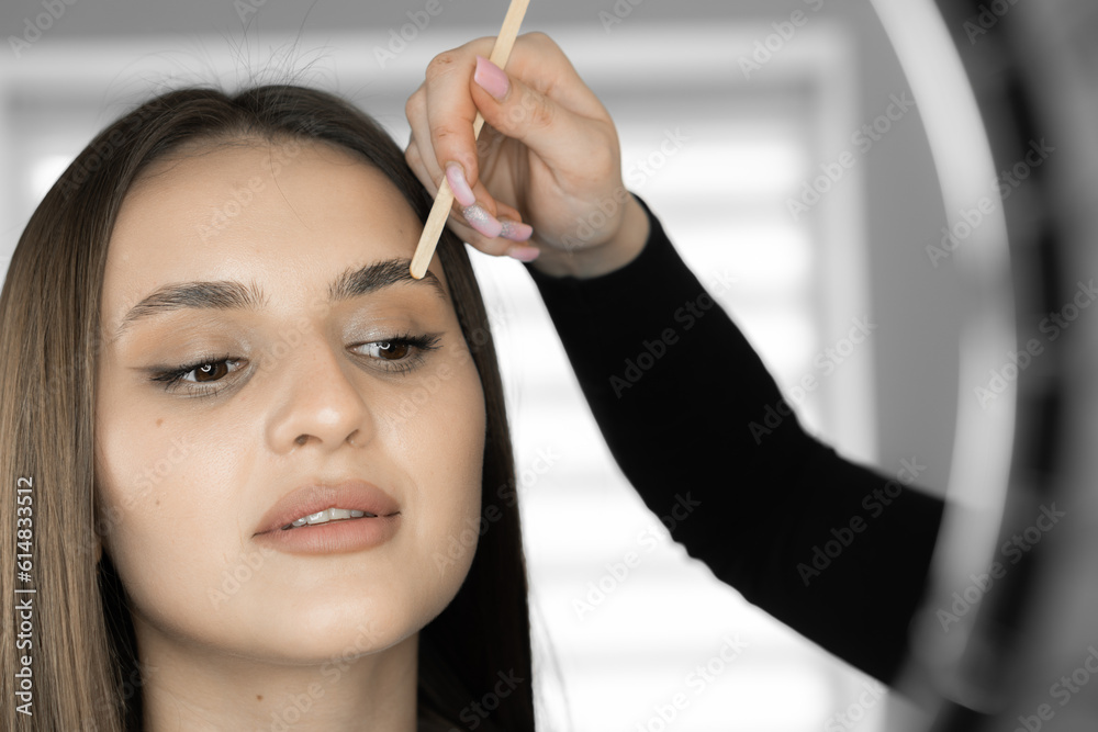In this photo, the eyebrow master designer carefully adjusts the ...