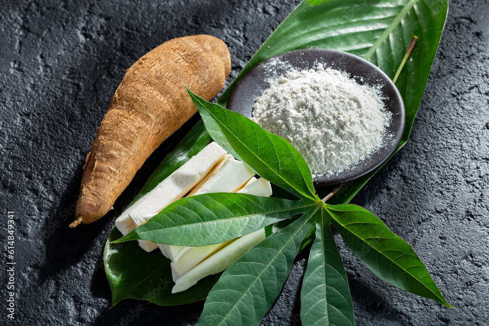 pile of cassava fruit and cassava flour on a background of rustic and ...