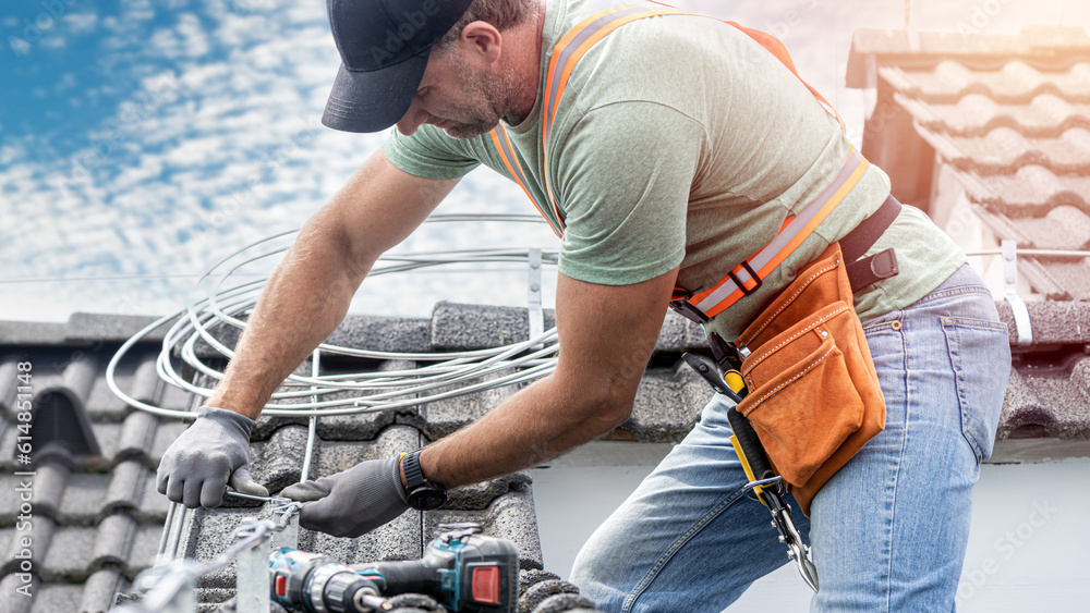 Work on the roof. An electrician`s hands turning screw using a spanner ...