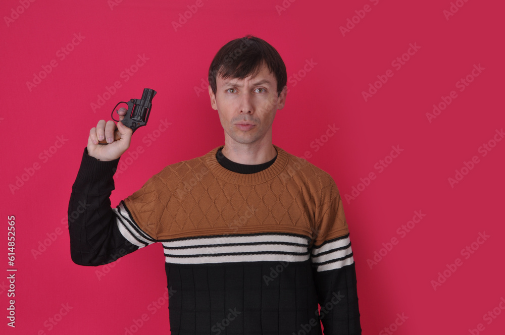 Foto de homem com pistola arma de fogo em fundo rosa do Stock | Adobe Stock