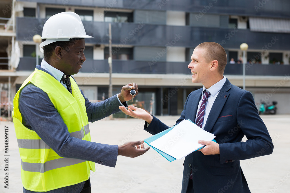 African-american contractor working on a construction site hands the ...