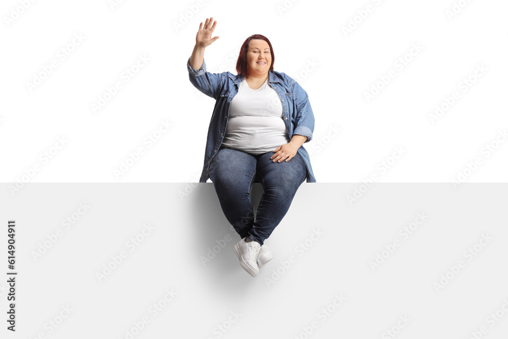 Young corpulent woman sitting on a blank panel and waving Stock Photo ...