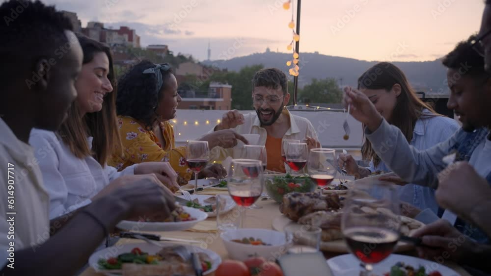Group of people eating during an outdoor dinner. Table with fresh food ...