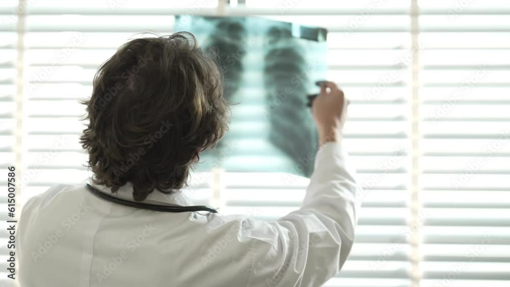 Doctor in room and radiologist discuss diagnosis while watching ...