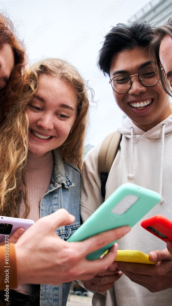 Group of multiracial classmate students looking at their smartphones ...