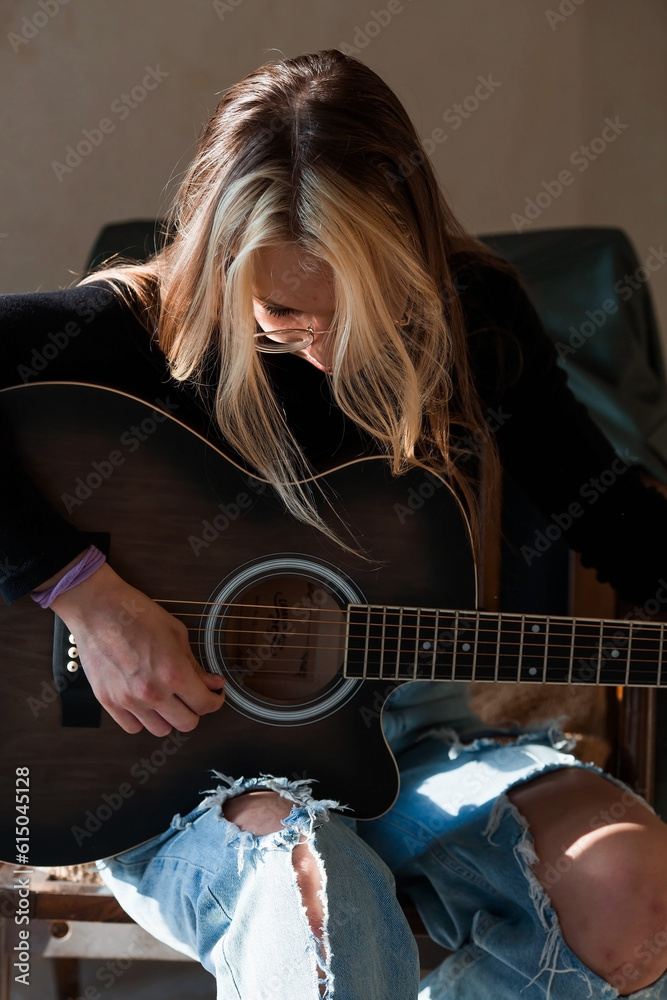 Music and hobbies. A talented young musician girl sits alone and ...