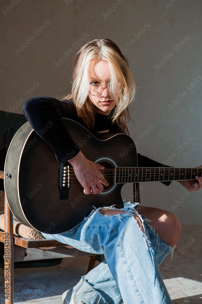 Music and hobbies. A talented young musician girl sits alone and ...