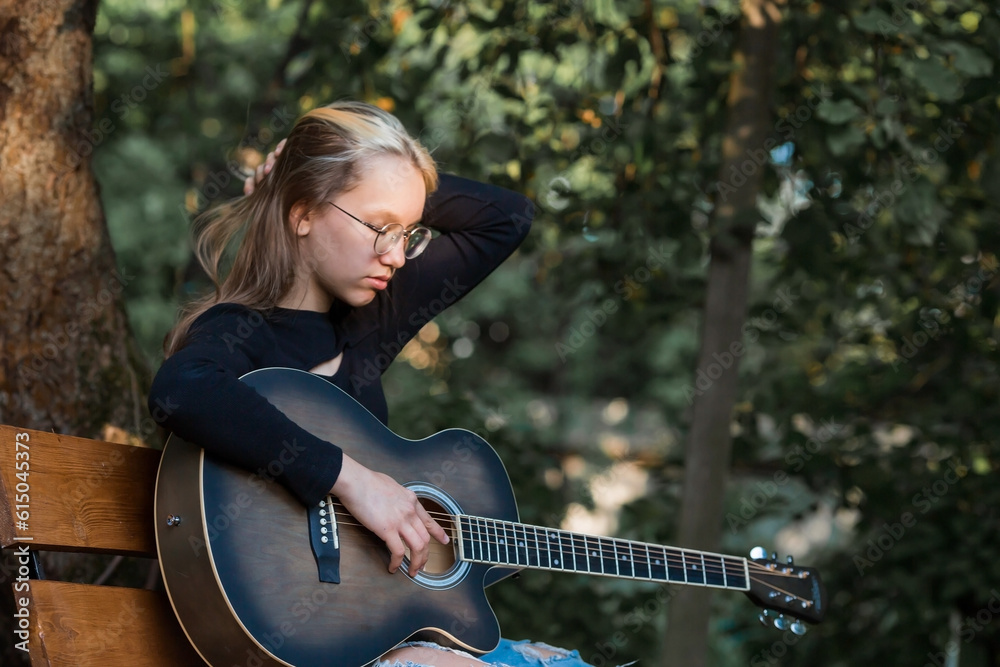 Music and hobbies. A talented young musician girl sits alone and ...
