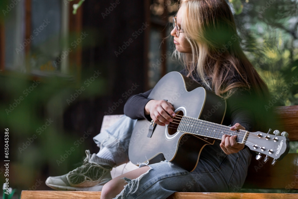 Music and hobbies. A talented young musician girl sits alone and ...