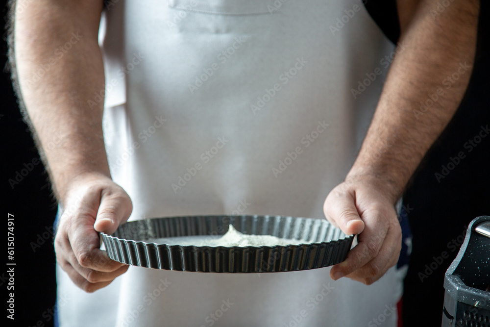 Half body shot of male chef wearing his uniform holding tray in the ...
