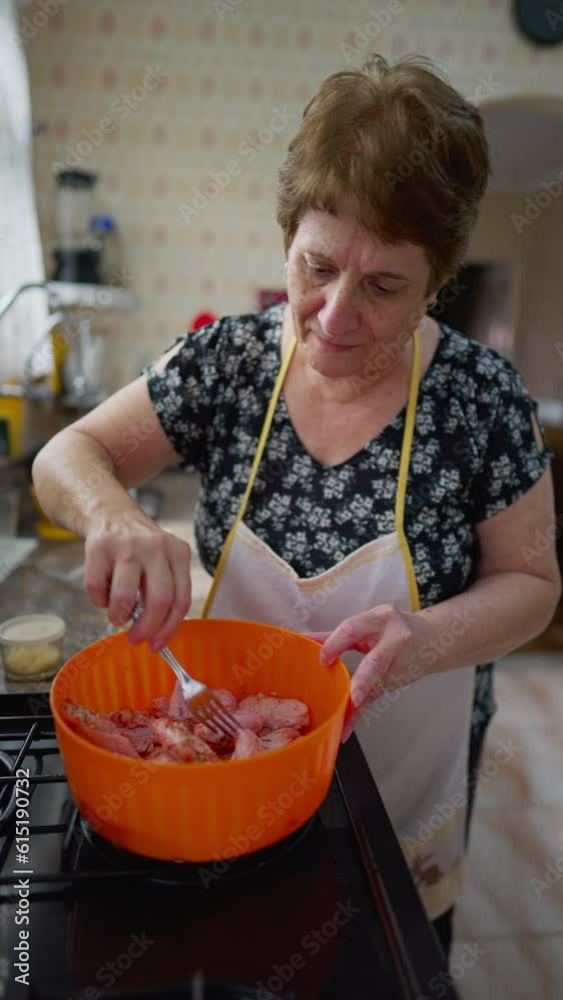 Traditional Senior woman cooking, mixing and seasoning food. One ...
