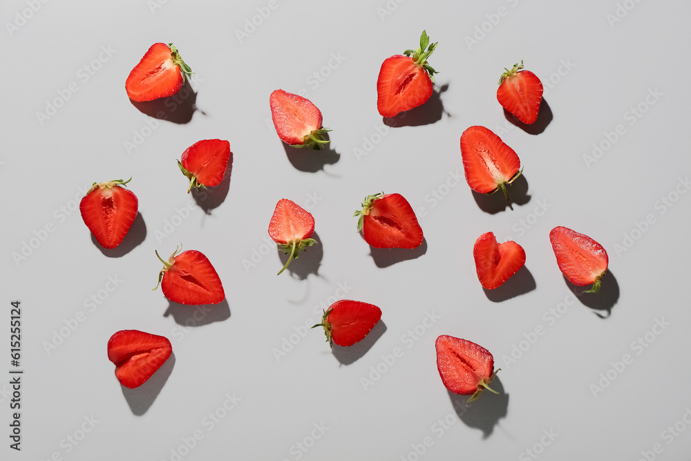 Halves of fresh strawberries on grey background Stock Photo | Adobe Stock