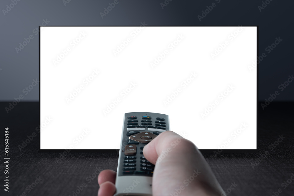 Television on gray wall and remote control in hand. Watching online TV ...