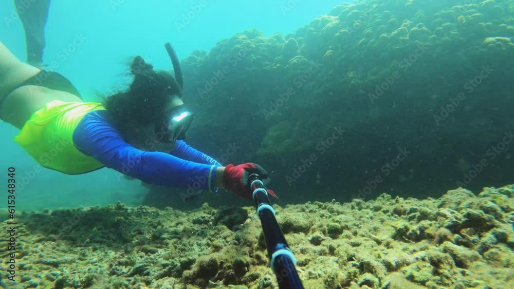 selfie of side view of an asian female free diver wearing bikini wet suit and snorkel mask ...