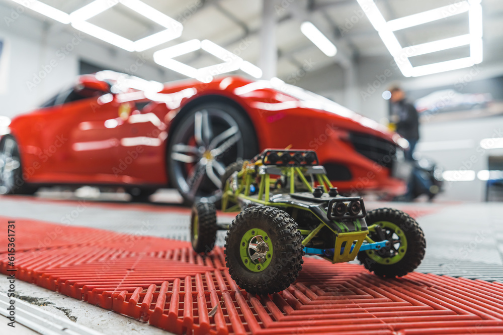 Comparison between toy car and sports car. Off-roader toy car in front ...