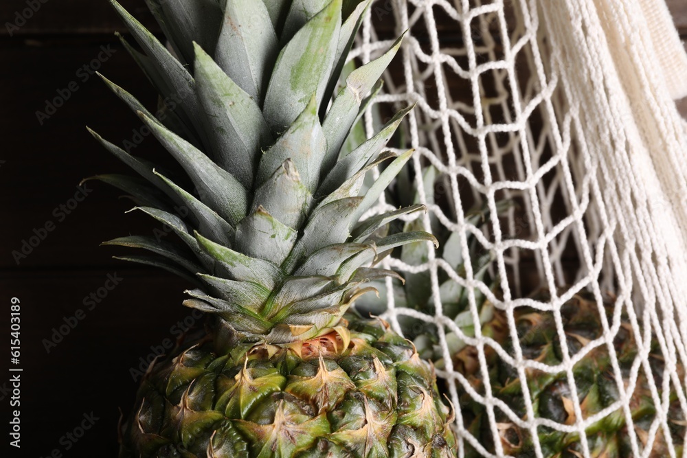 Whole ripe pineapples and net bag, closeup Stock Photo | Adobe Stock