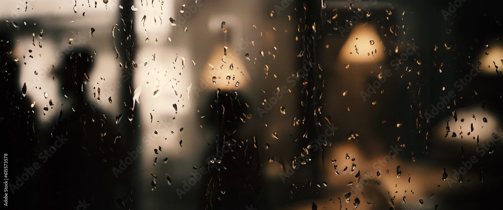 Rain drop on window glass of coffee shop and blurry city life ...