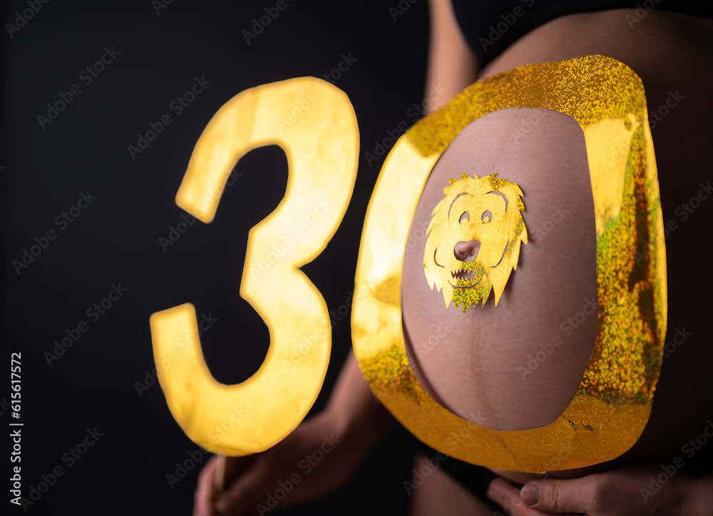Baby bump shot with glittering lion sticker and 30 birthday shield from ...