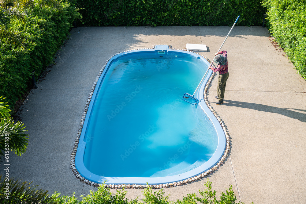 Housekeeping using a long skimmer for removing fallen leaves and debris ...