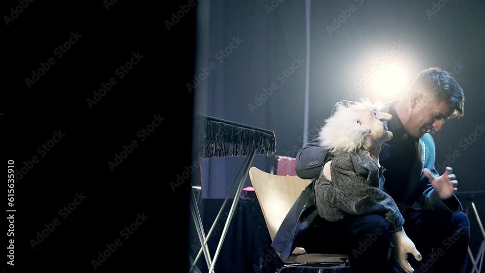 Backstage shot of a ventriloquist and puppet performing on stage with a ...
