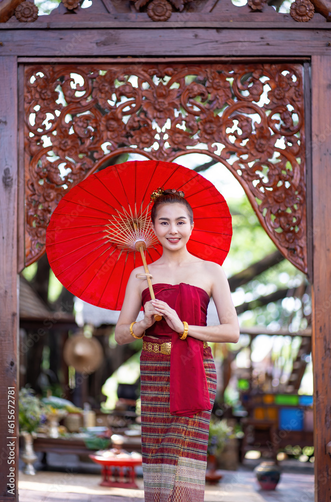 Beautiful Asian women wearing Thai traditional Lanna style dresses posing, holding a red ...