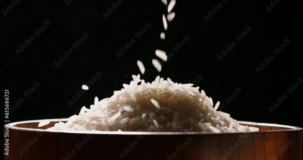 Rice fall into raw wooden cup side view black background White rice ...