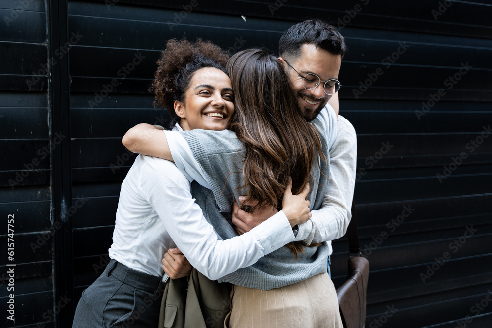 Cheerful businessman and businesswomen hugging each other in front of ...