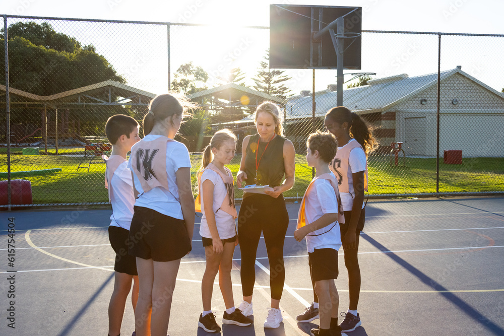 school children at netball training with coach who is a mum Stock Photo ...