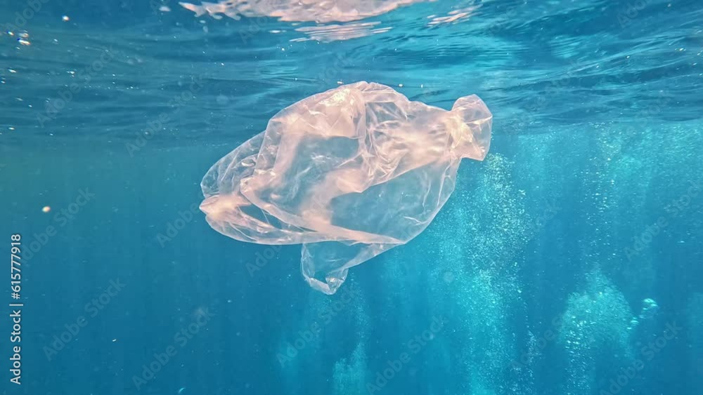 Piece of plastic bag floating in the sea. Danger of free-floating waste ...