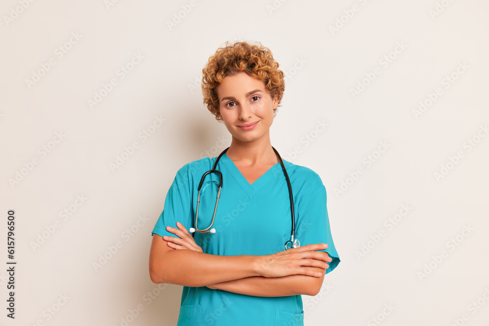 Cute young lady doctor in medical uniform holding hands crossed on her ...