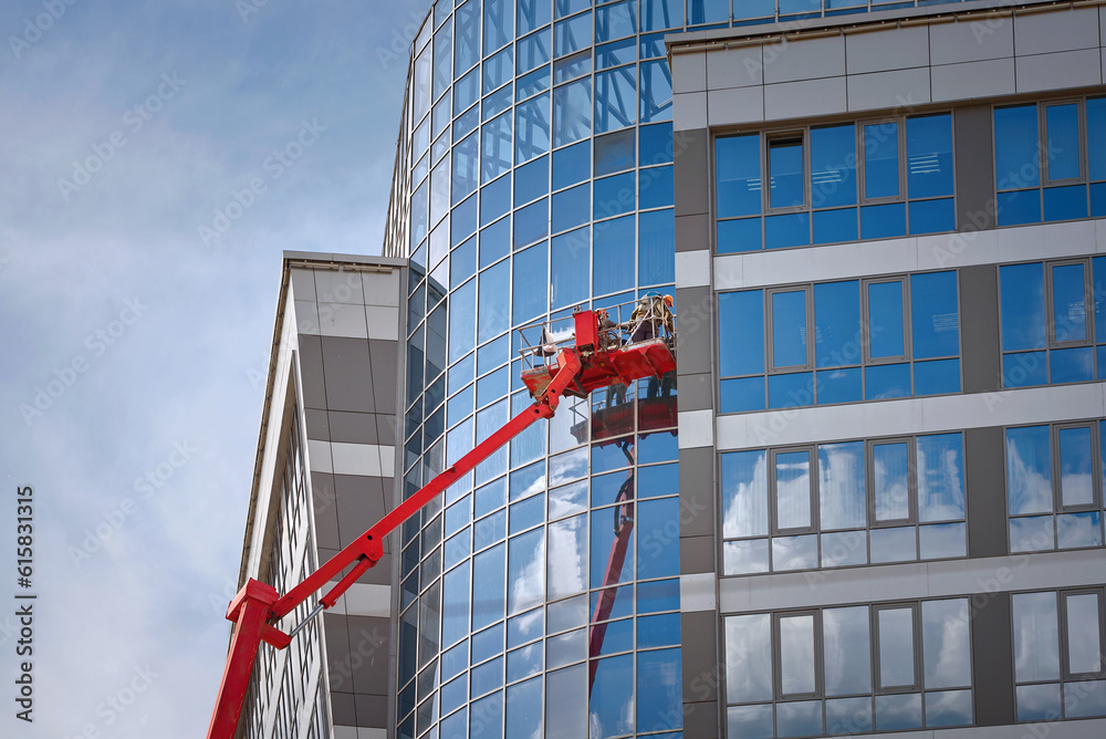 Foto de Glass facade cleaning work, workers washing windows at height ...