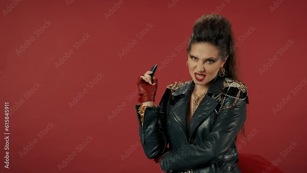 A female freak raises an electronic cigarette to her lips, inhales, and ...