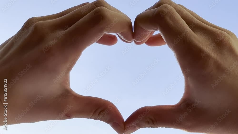 Hands showing a heart against the blue sky. World Day of Peace ...