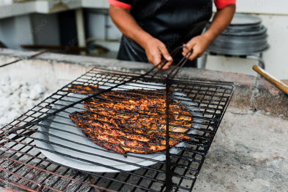 hands of mexican man cooking grilled fish traditional from Acapulco ...