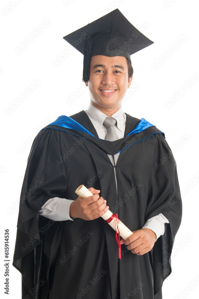 Happy male university student in graduation gown holding paper ...